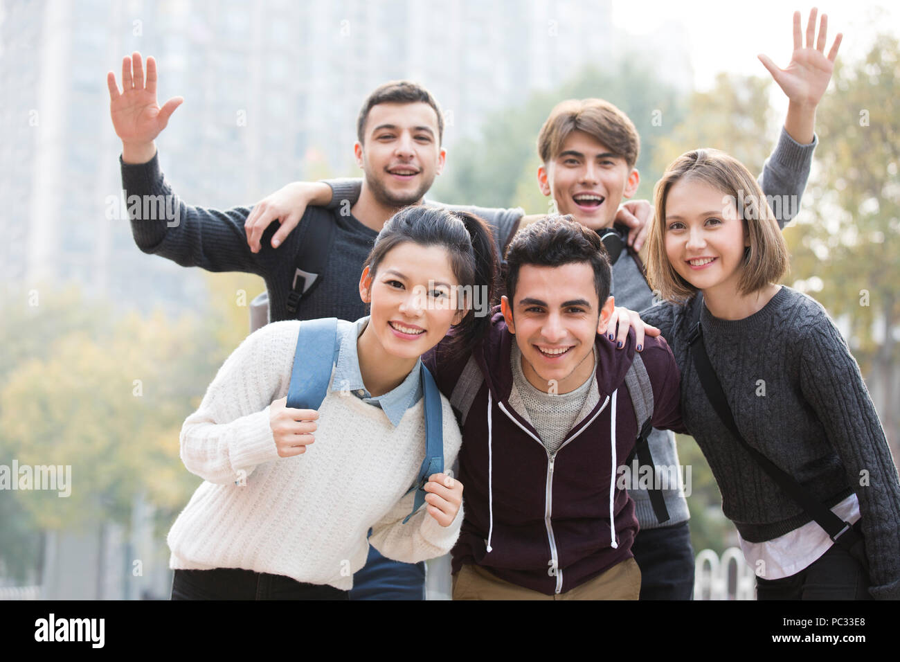 Group smiling students waving hi-res stock photography and images - Alamy