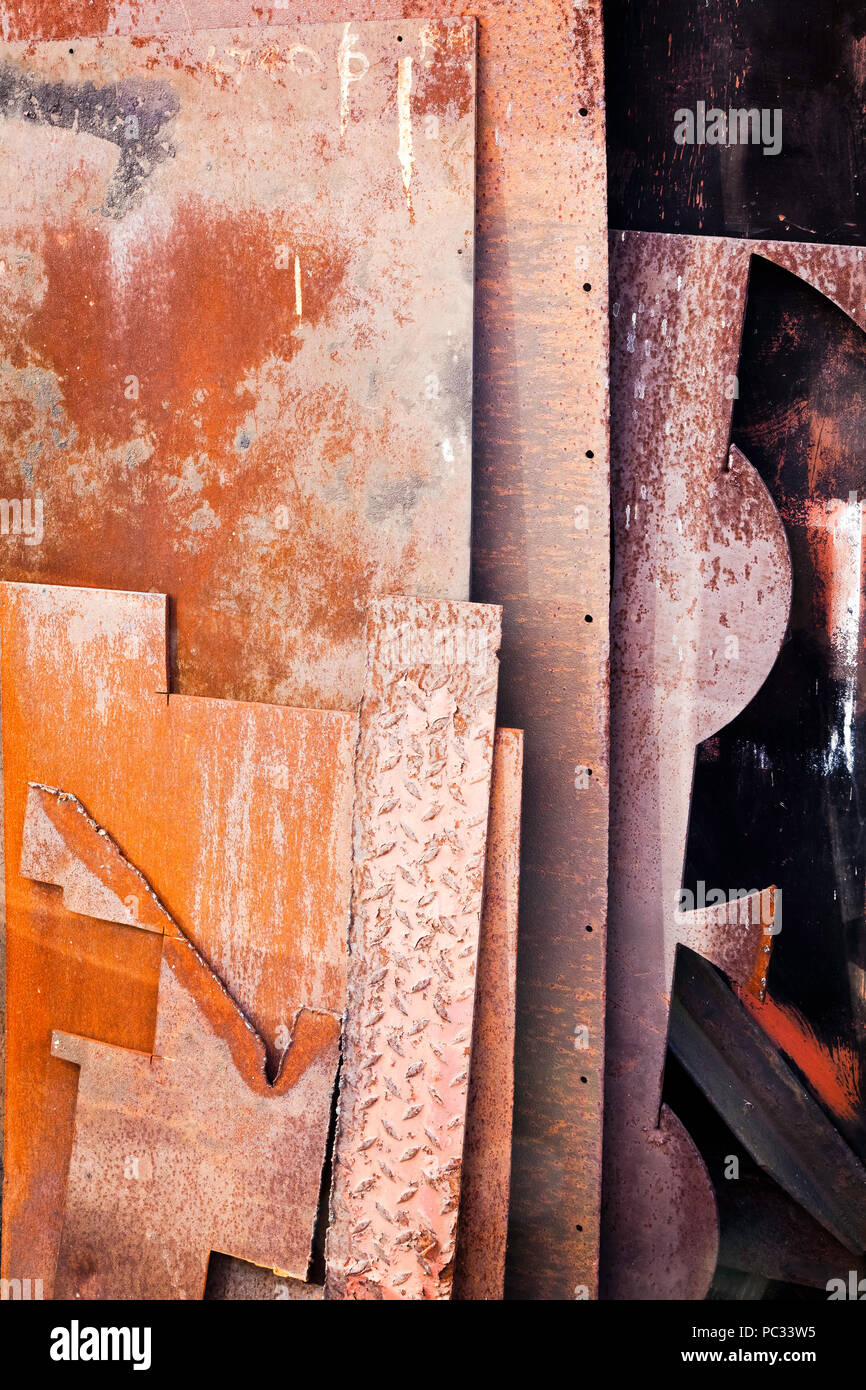 Rusty Metal sheets stacked up against a wall looking like a cubist ...