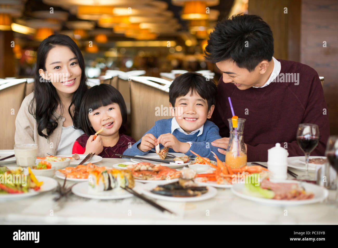 Cheerful young Chinese family having buffet dinner Stock Photo - Alamy