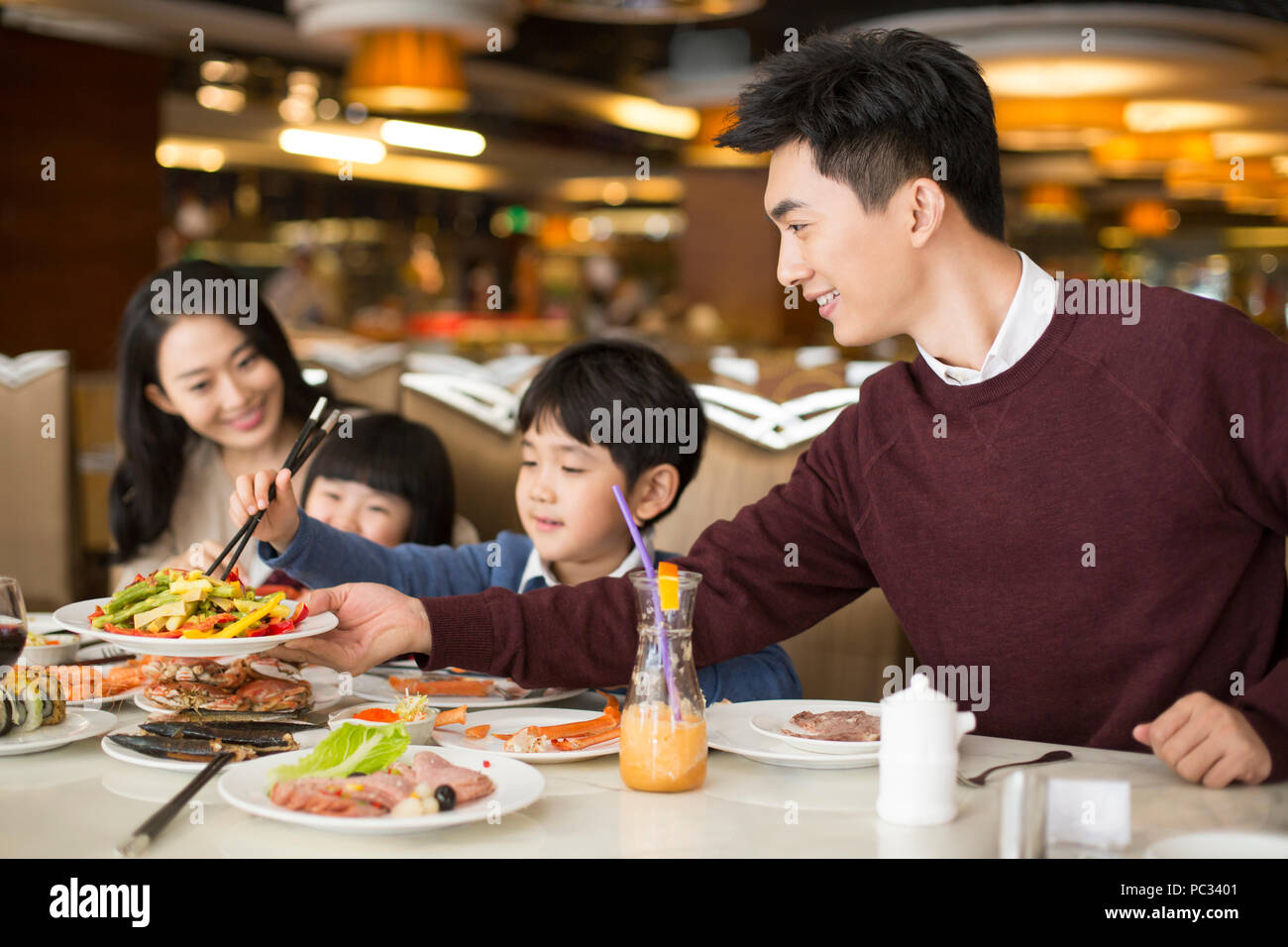 Cheerful young Chinese family having buffet dinner Stock Photo - Alamy