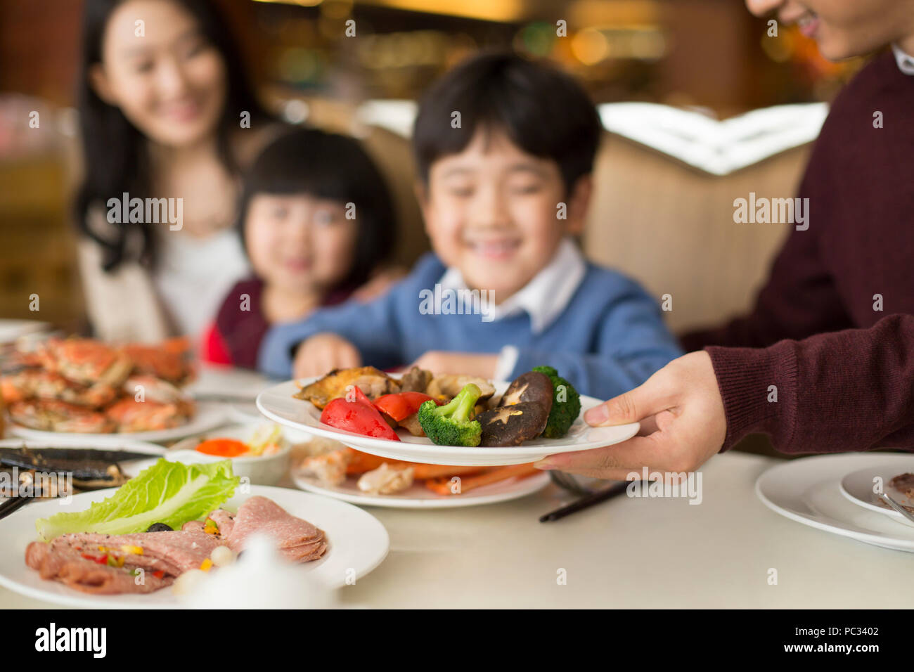 Cheerful young Chinese family having buffet dinner Stock Photo - Alamy