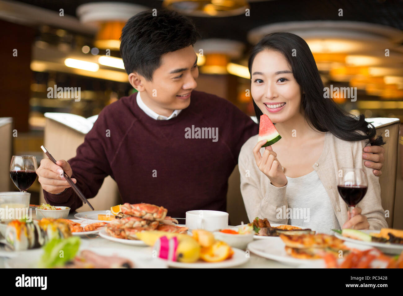 Cheerful young Chinese couple having buffet dinner Stock Photo - Alamy