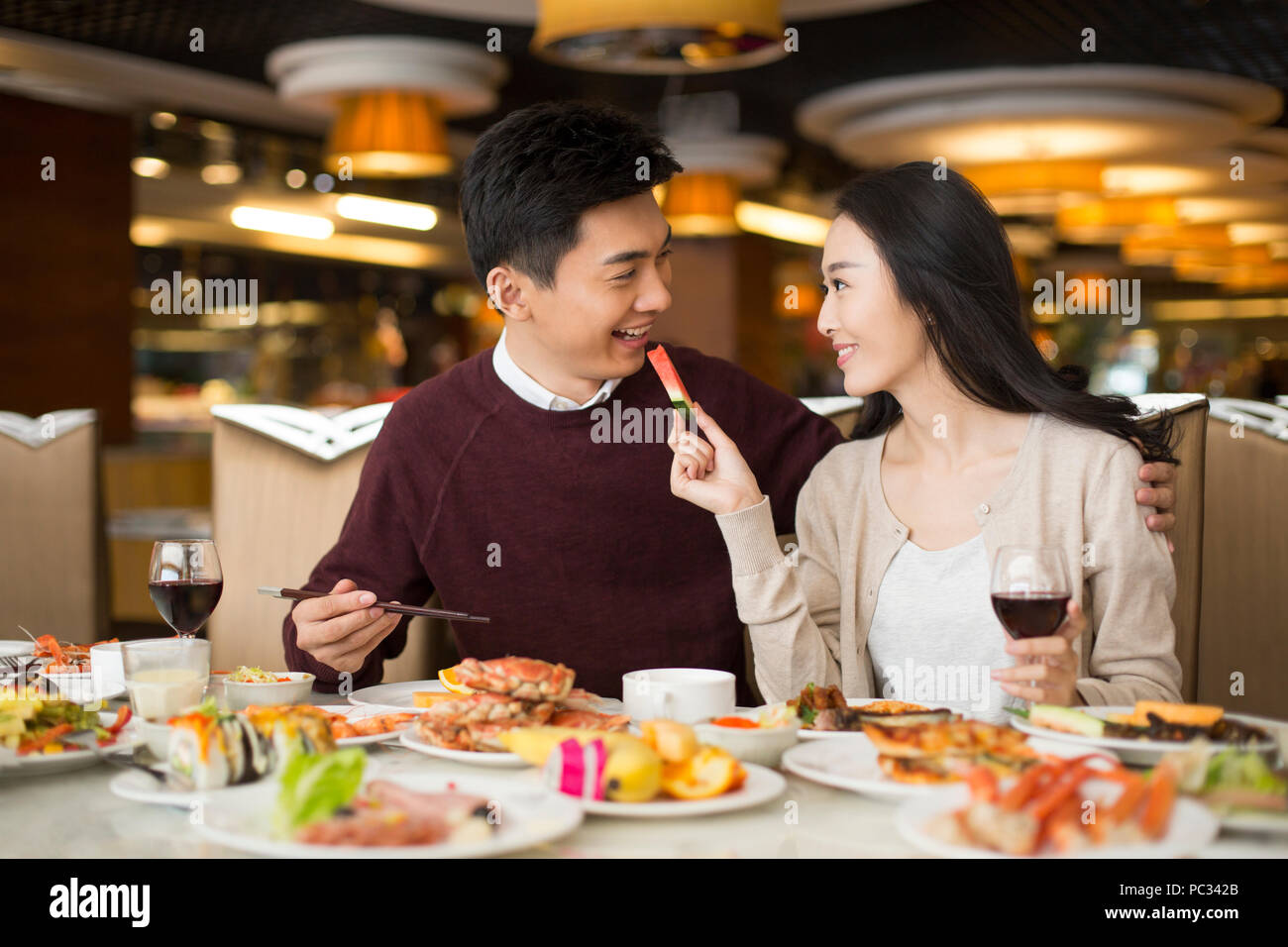 Cheerful young Chinese couple having buffet dinner Stock Photo - Alamy
