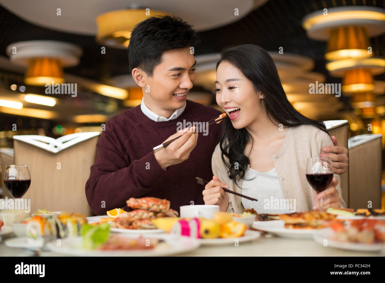 Cheerful young Chinese couple having buffet dinner Stock Photo - Alamy