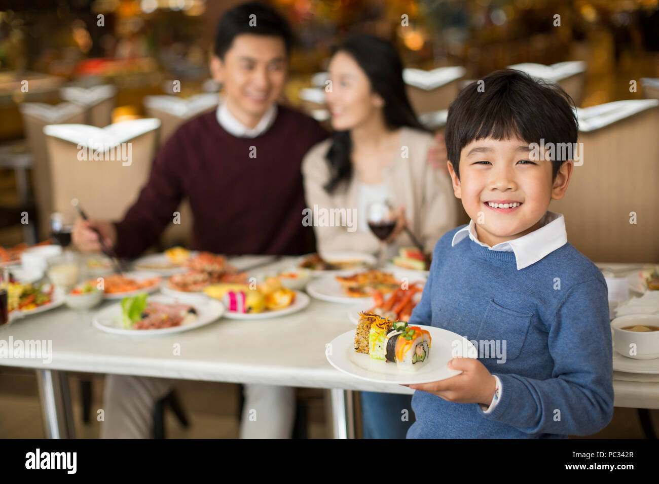 Cheerful young Chinese family having buffet dinner Stock Photo - Alamy