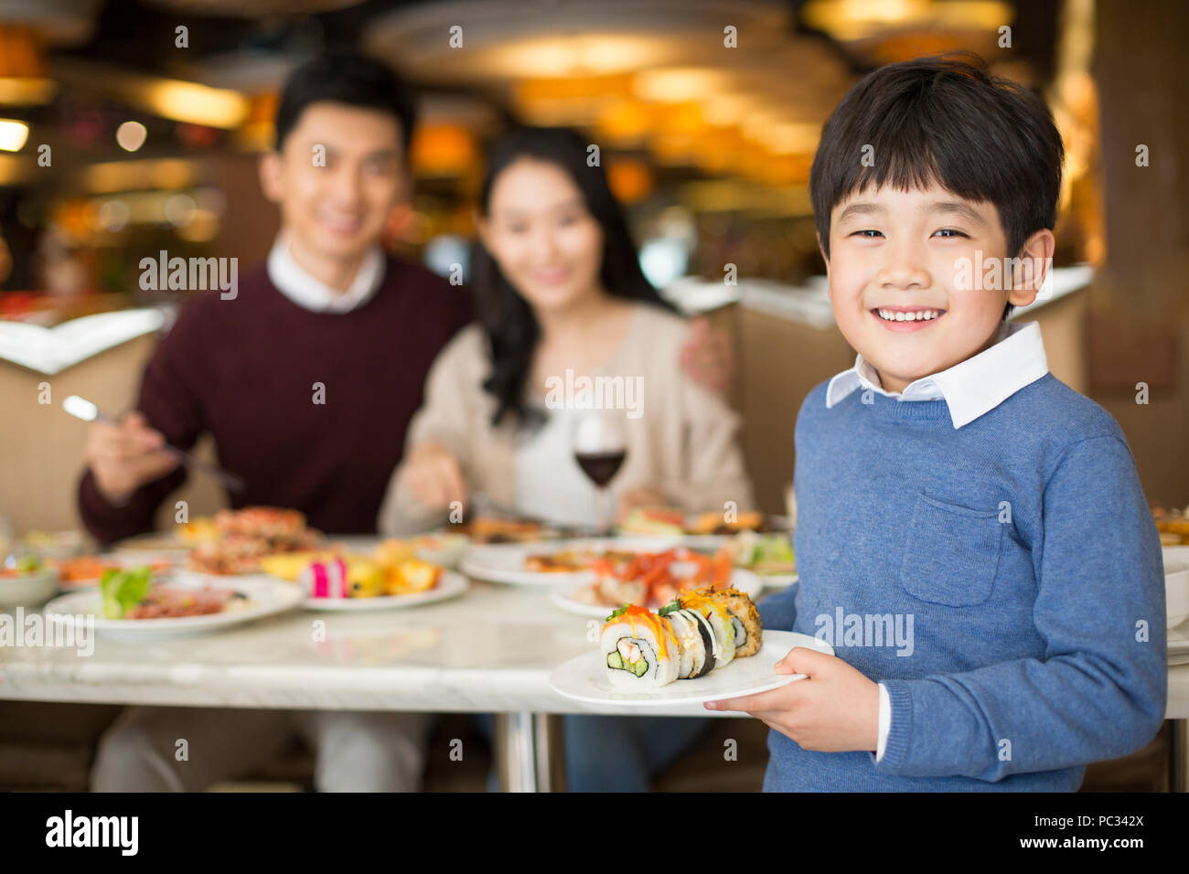 Cheerful young Chinese family having buffet dinner Stock Photo - Alamy