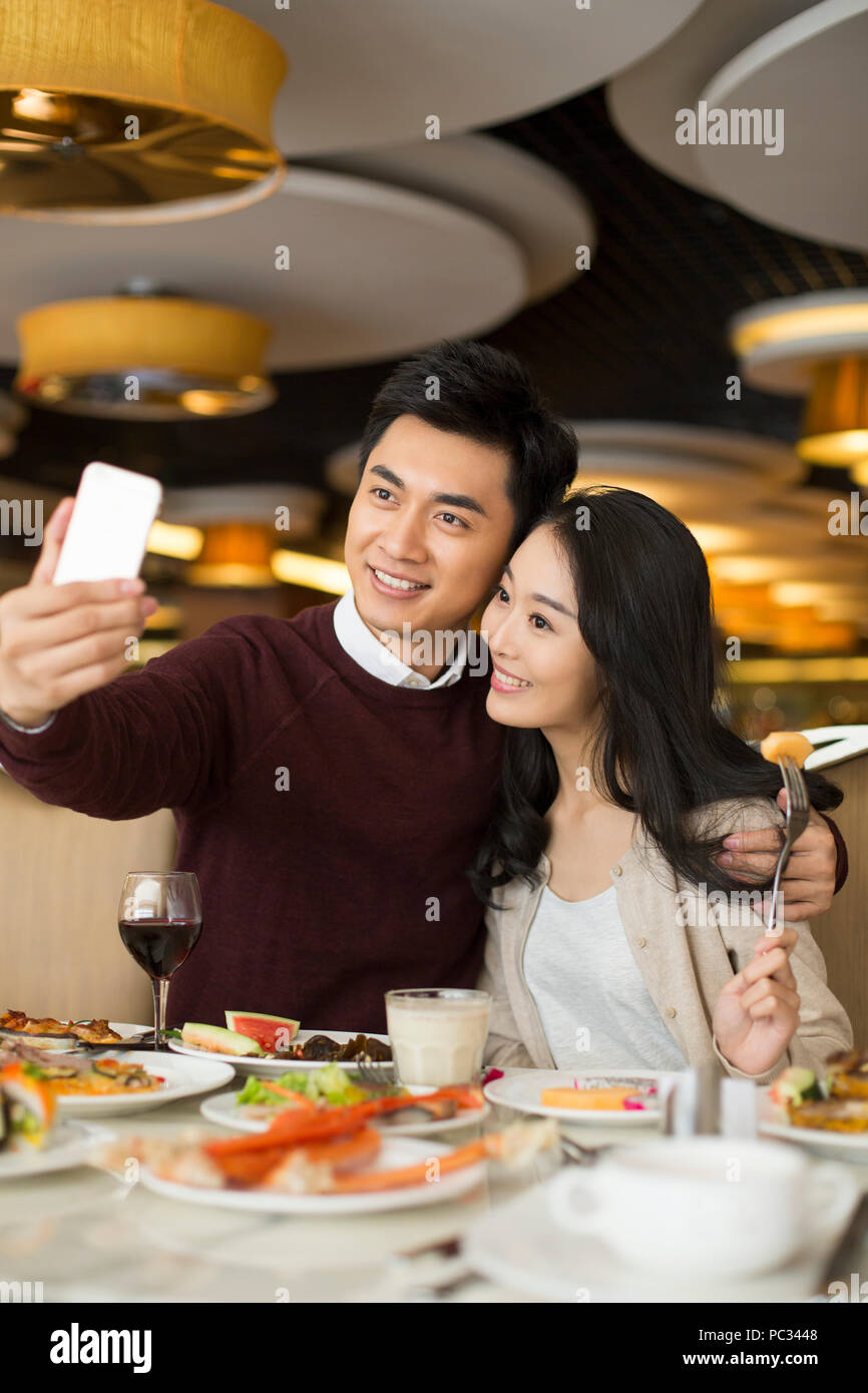 Cheerful young Chinese couple having buffet dinner Stock Photo - Alamy