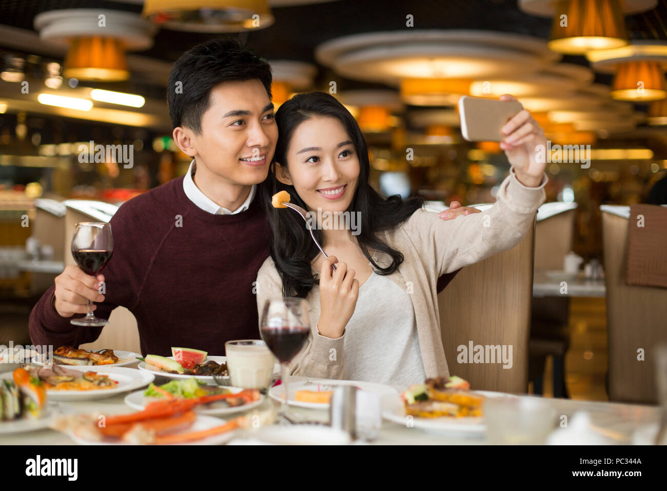 Cheerful young Chinese couple having buffet dinner Stock Photo - Alamy