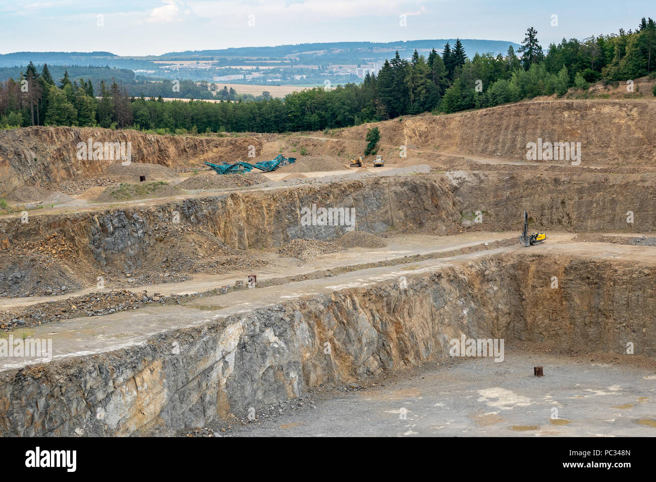 Opencast mining quarry with lots of machinery. Mining in the granite ...