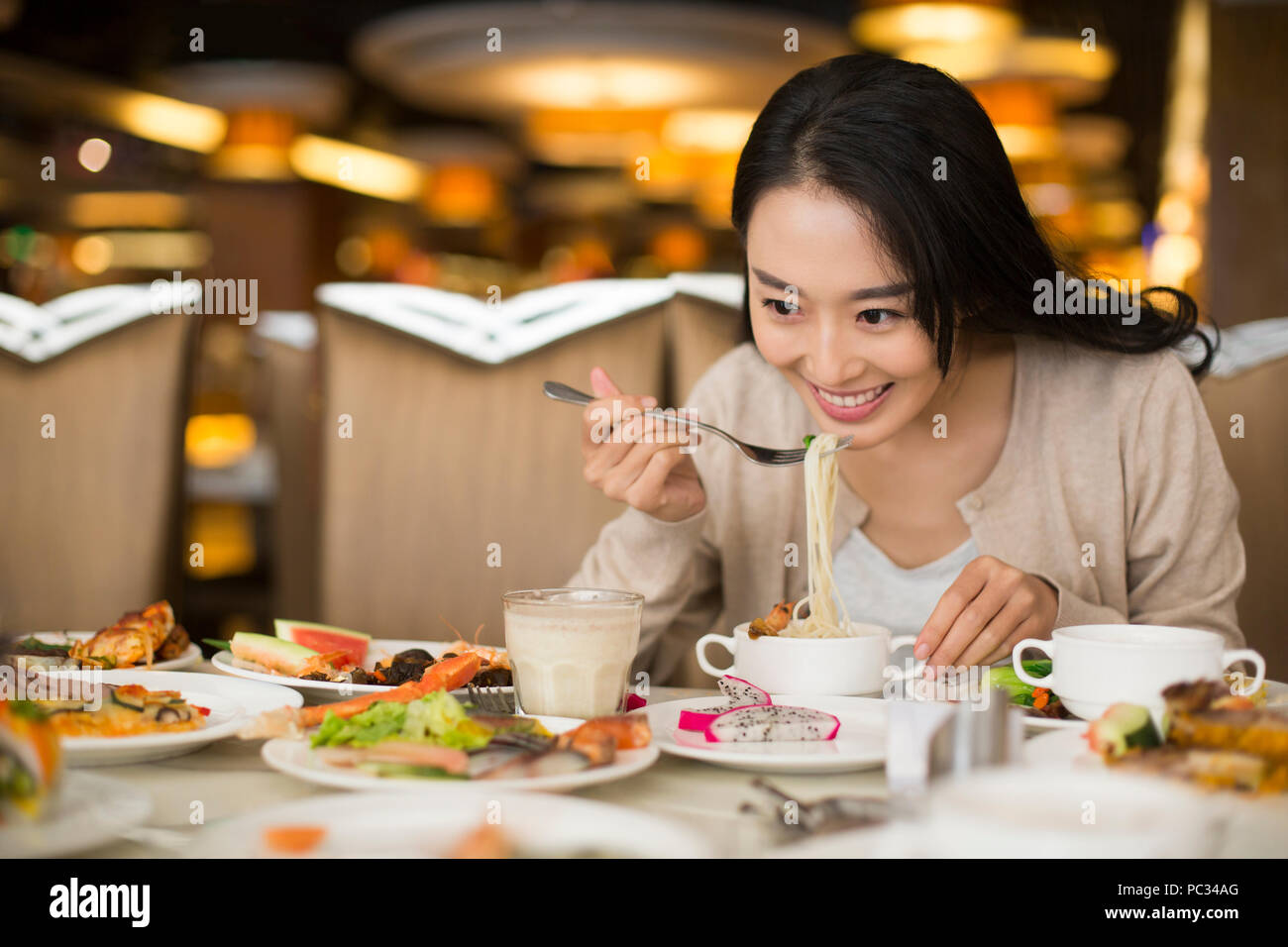 Cheerful young Chinese woman having buffet dinner Stock Photo - Alamy