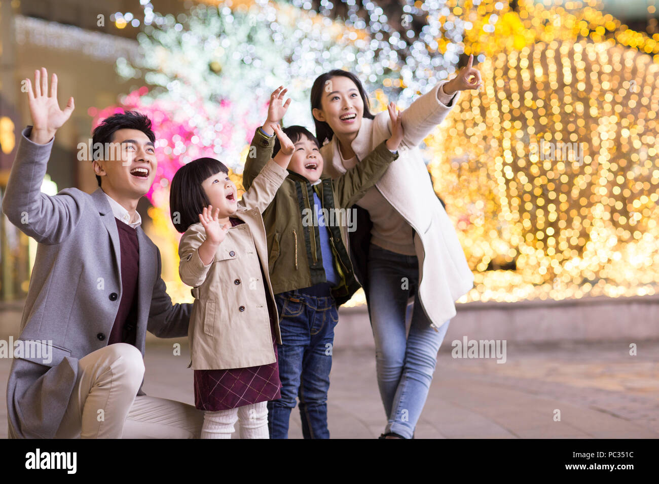 Cheerful young Chinese family waving Stock Photo - Alamy