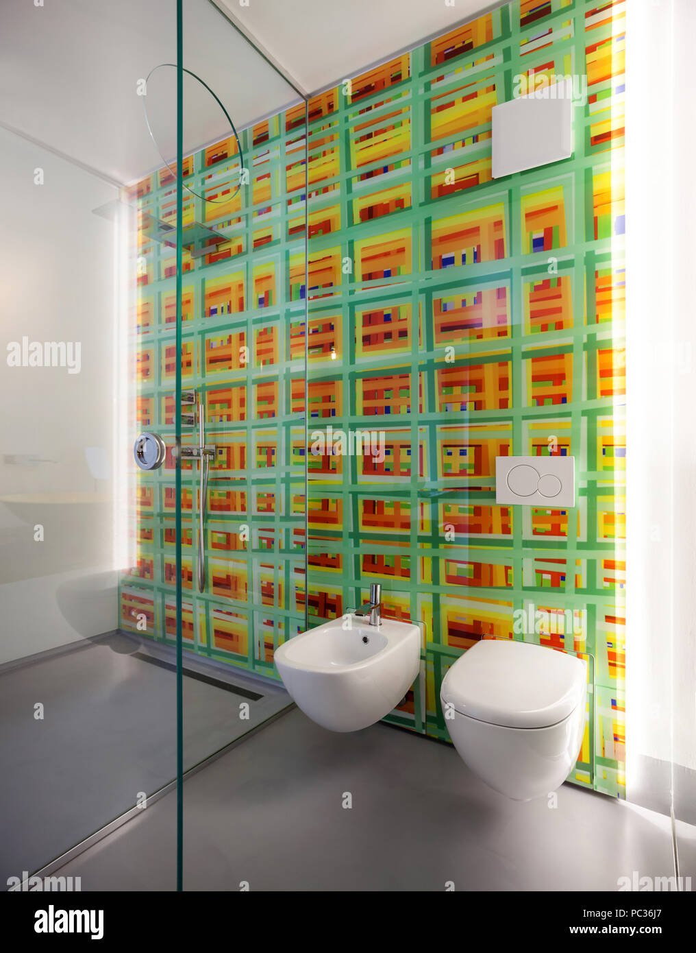 Modern bathroom, toilet and bidet and colored tiles on the wall Stock ...