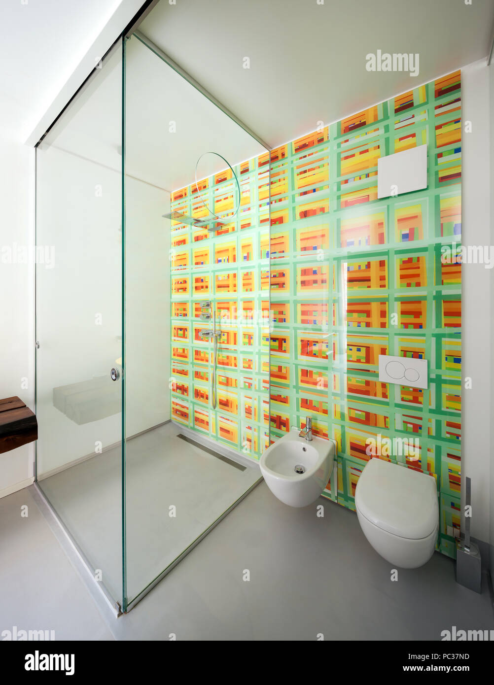 Modern bathroom, toilet and bidet and colored tiles on the wall Stock ...