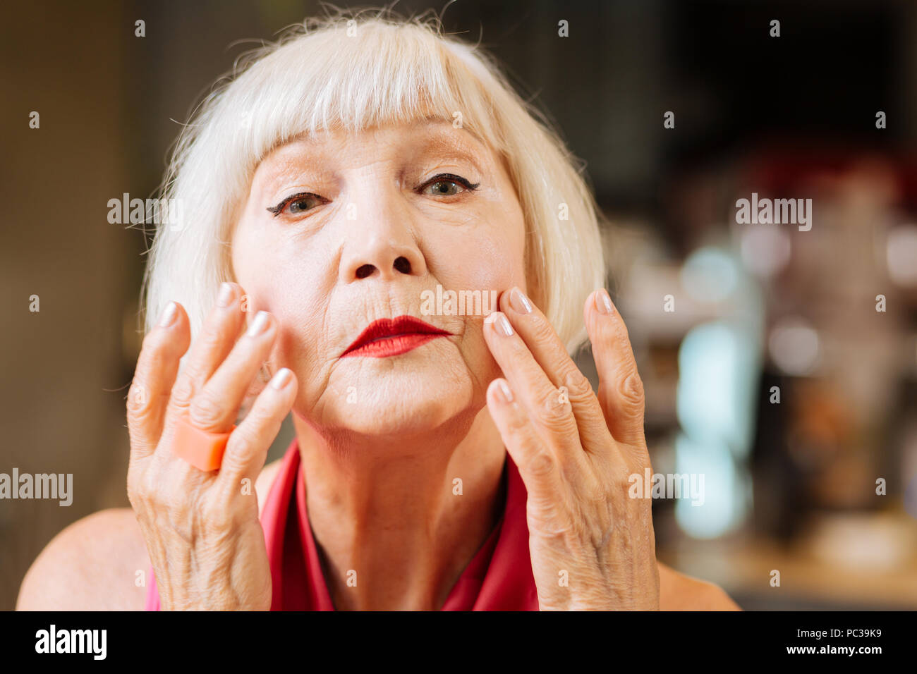Facial care. Portrait of a nice good looking woman touching her cheeks ...