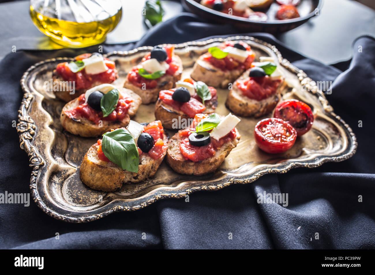 Bruschetta toast with mozzarella tomatoes olives basil and olive oil ...