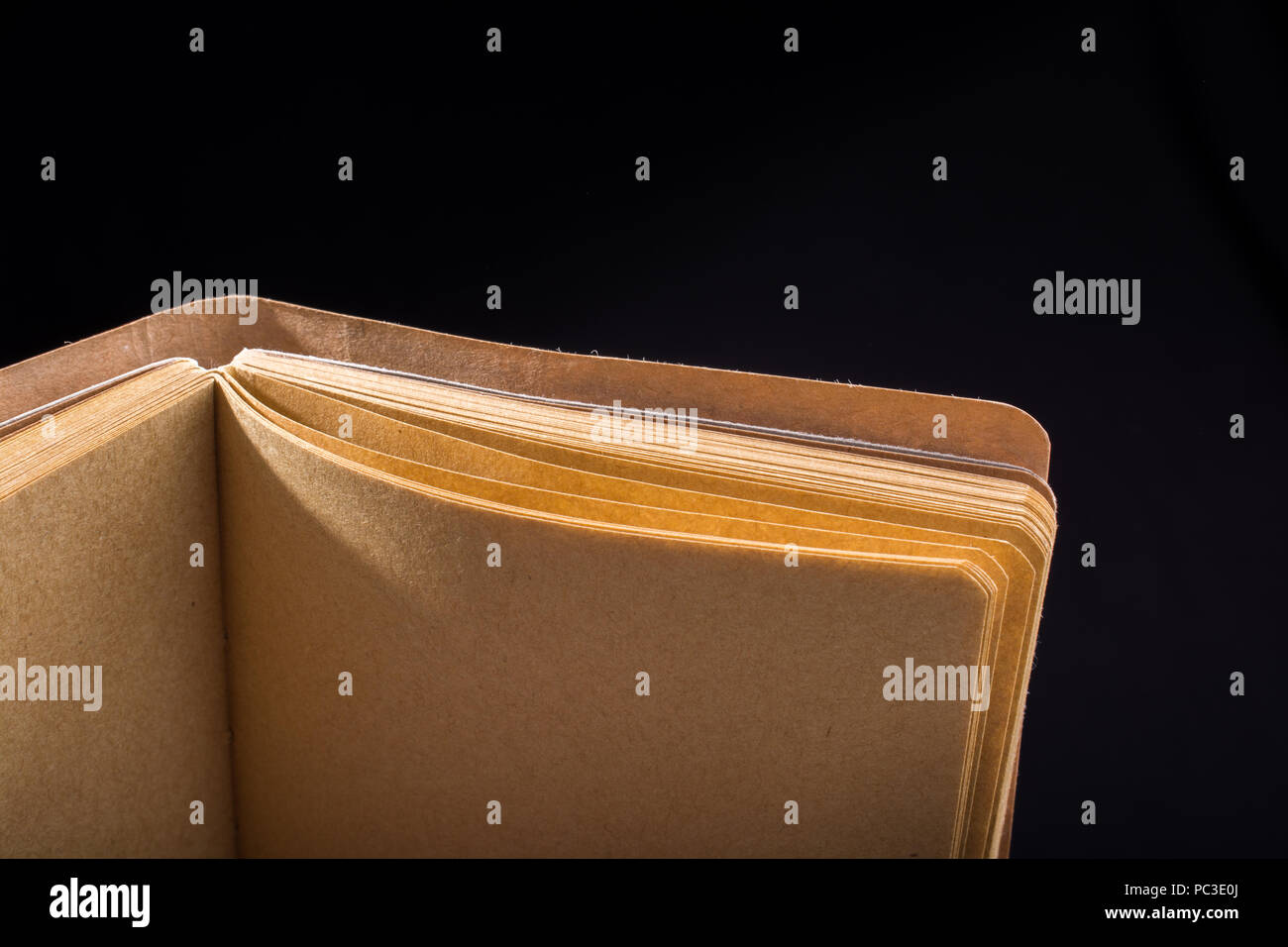Brown color notebook open on a black background Stock Photo - Alamy