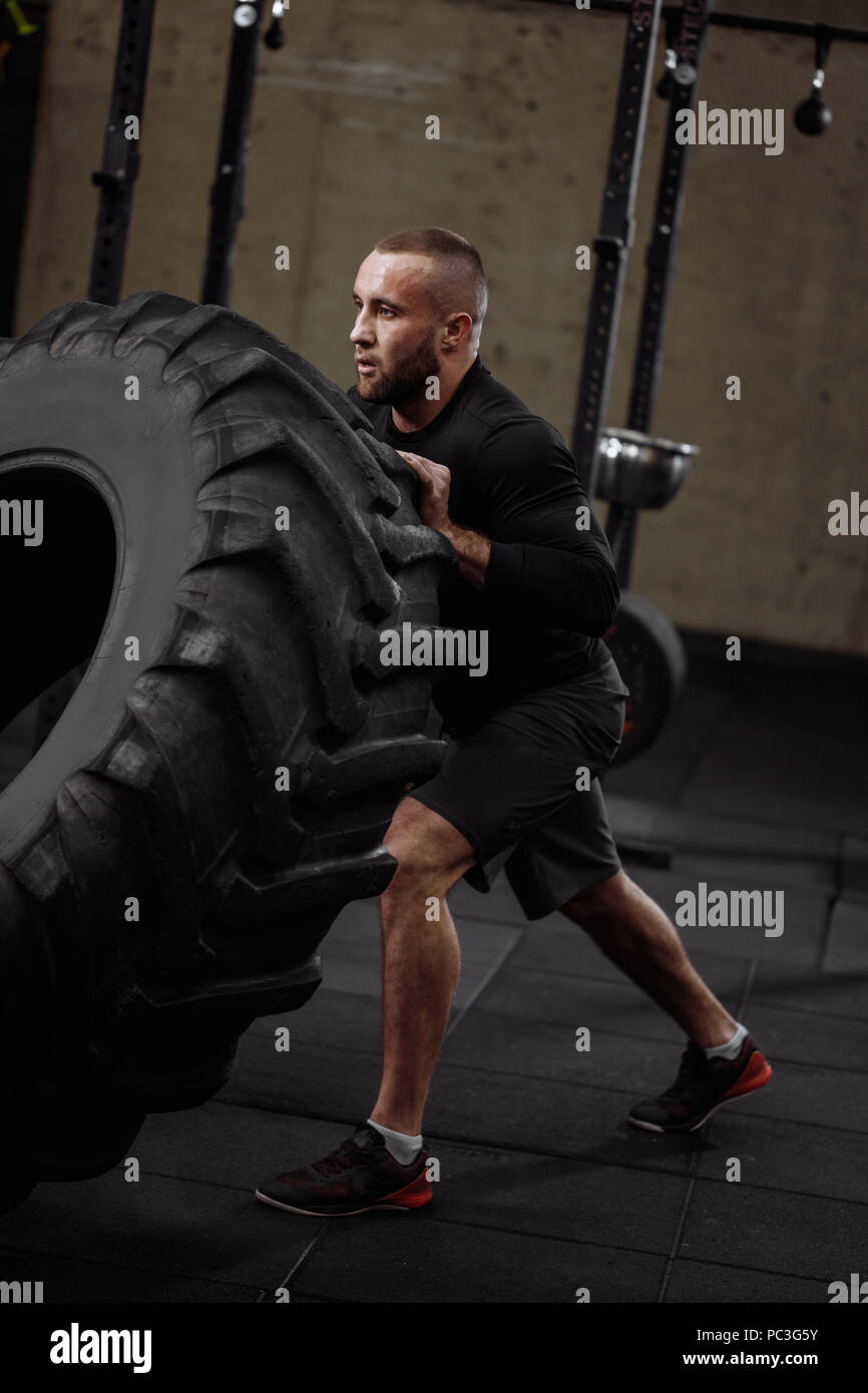 well-built bodybuilder is concentrated on his training. fitness regime ...