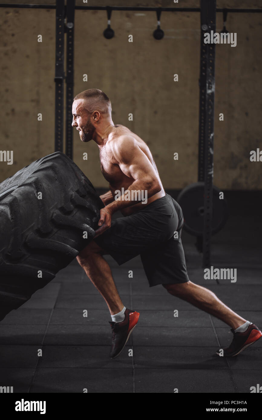young handsome healthy man with tensed face performing exercise with ...