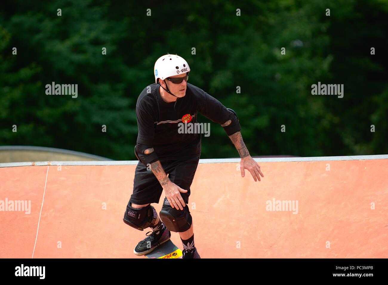 Adult man skateboarding in park with protection gear on Stock Photo - Alamy