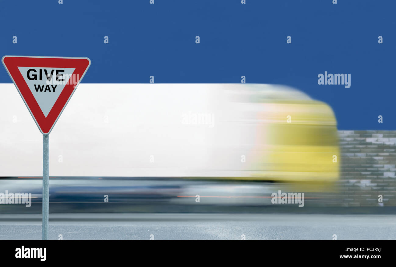 Give way text yield road sign, motion blurred truck vehicle traffic ...
