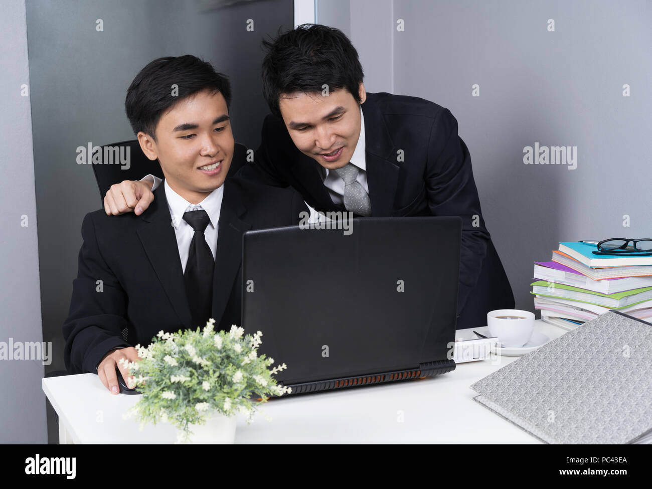 two business man laughing while using a laptop computer Stock Photo - Alamy