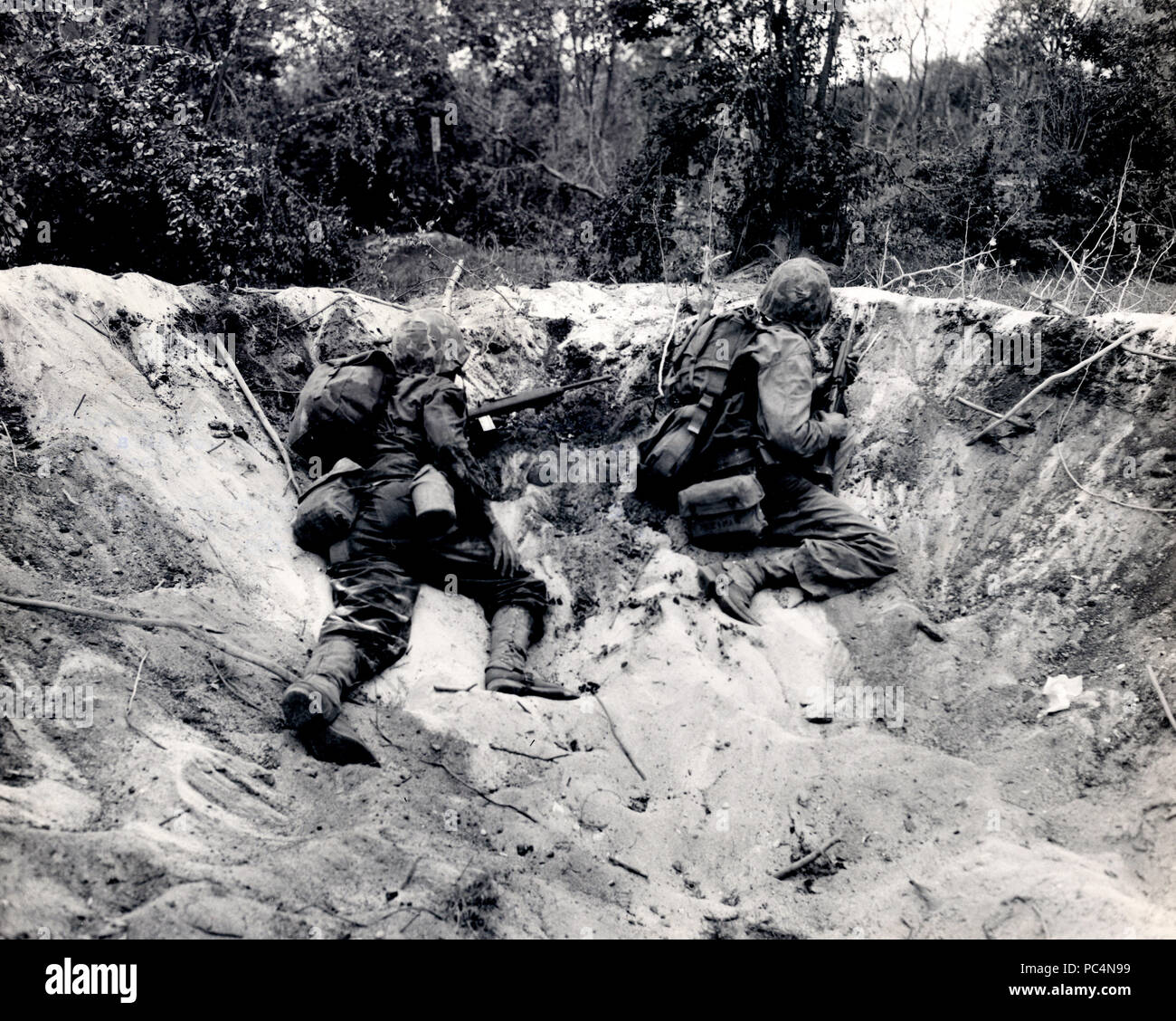 Marines crouch low in a shell hole on Saipan Stock Photo - Alamy