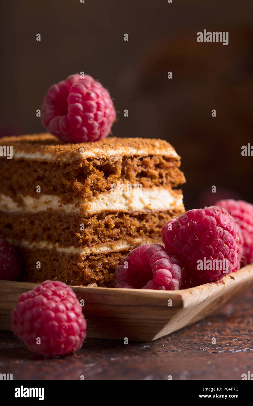 Homemade layered honey cake with cream and red raspberries Stock Photo ...