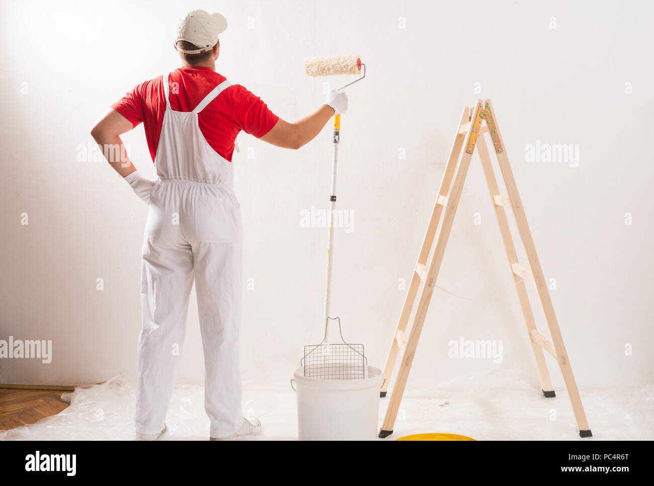 Young Man On Painting Wall With Roller Stock Photo - Alamy