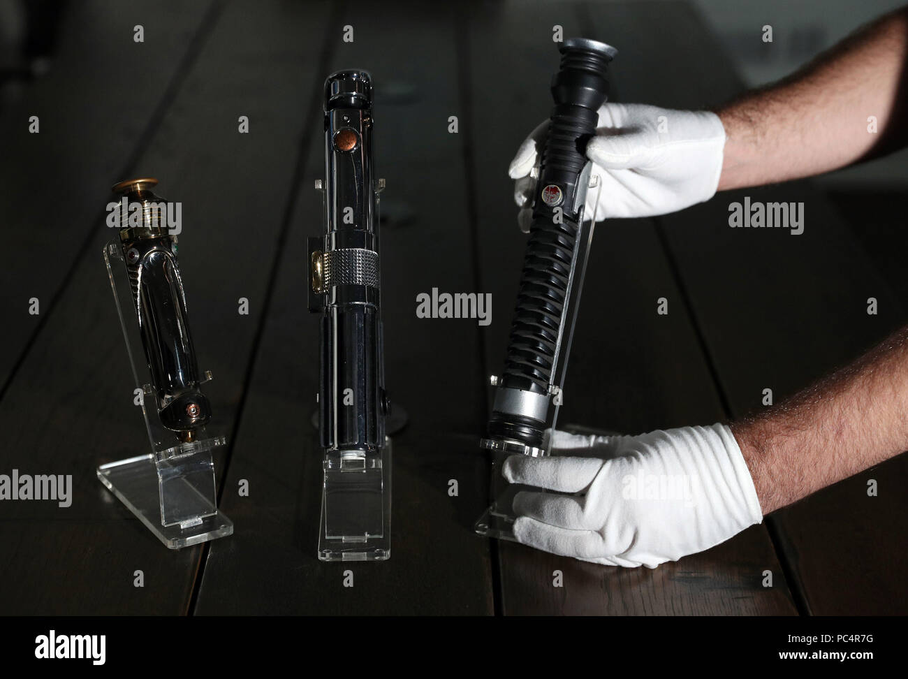 A Prop Store employee adjusts a lightsaber used by Liam Neeson in Star ...