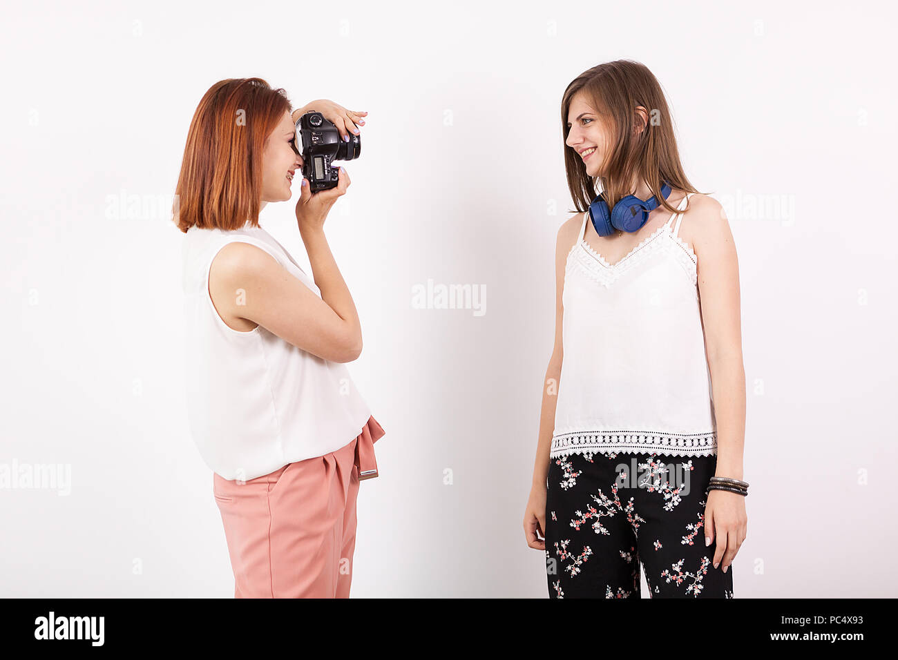 Woman photographer and her female friend taking pictures in studio over ...