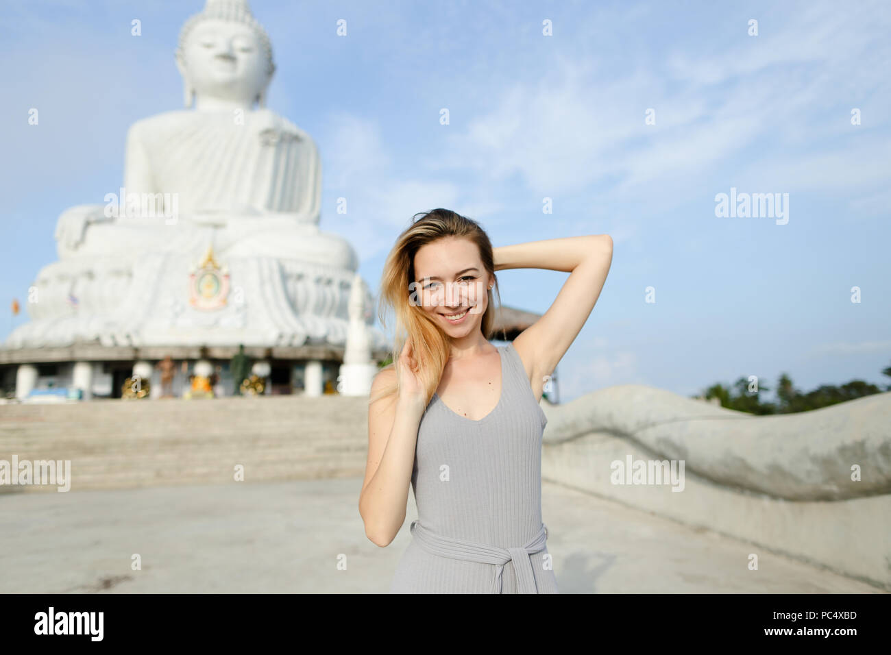 Young woman standing near concrete statue of Buddha in Phuket Stock ...