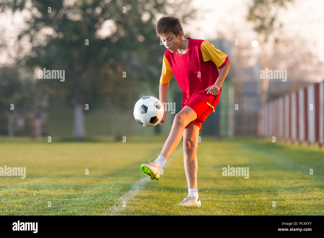 Child playing football on a soccer field Stock Photo - Alamy
