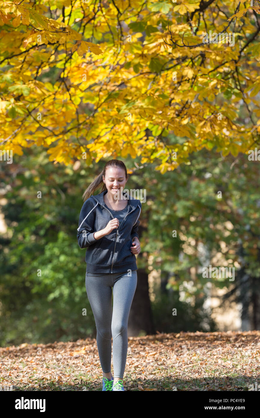Pretty young girl jogging in the park Stock Photo - Alamy