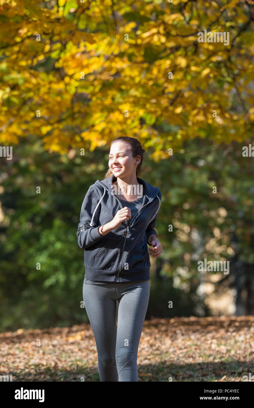 Pretty young girl jogging in the park Stock Photo - Alamy