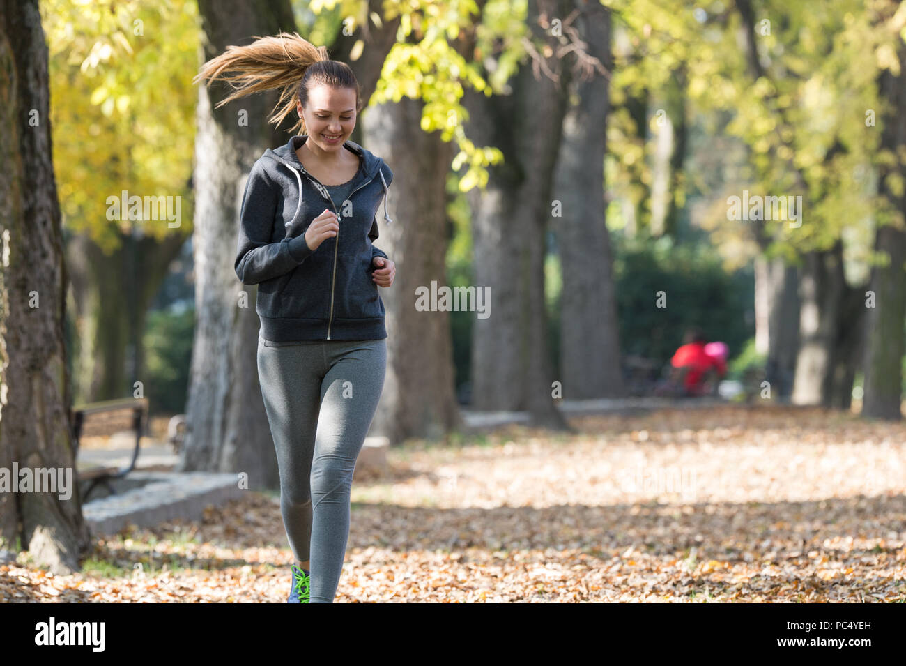Pretty young girl jogging in the park Stock Photo - Alamy