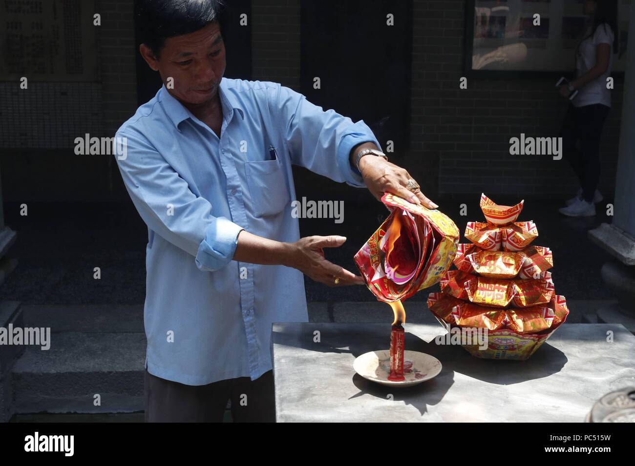 Taoist temple. Phuoc An Hoi Quan Pagoda. Man burning tradional joss ...