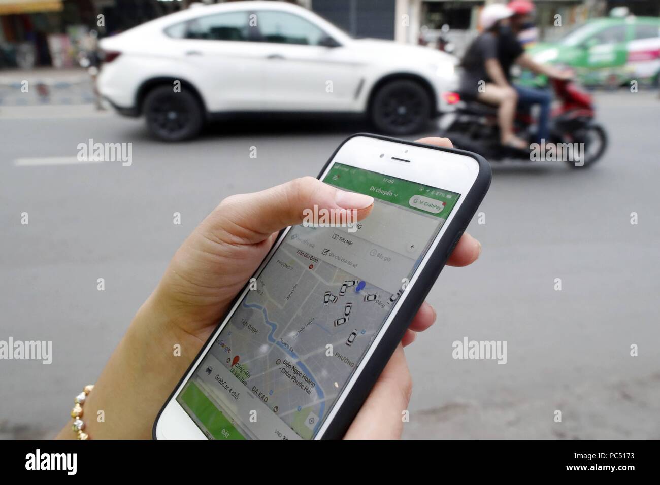 Woman using the Grab app on an Apple iPhone 6 Ho Chi Minh City. Vietnam ...