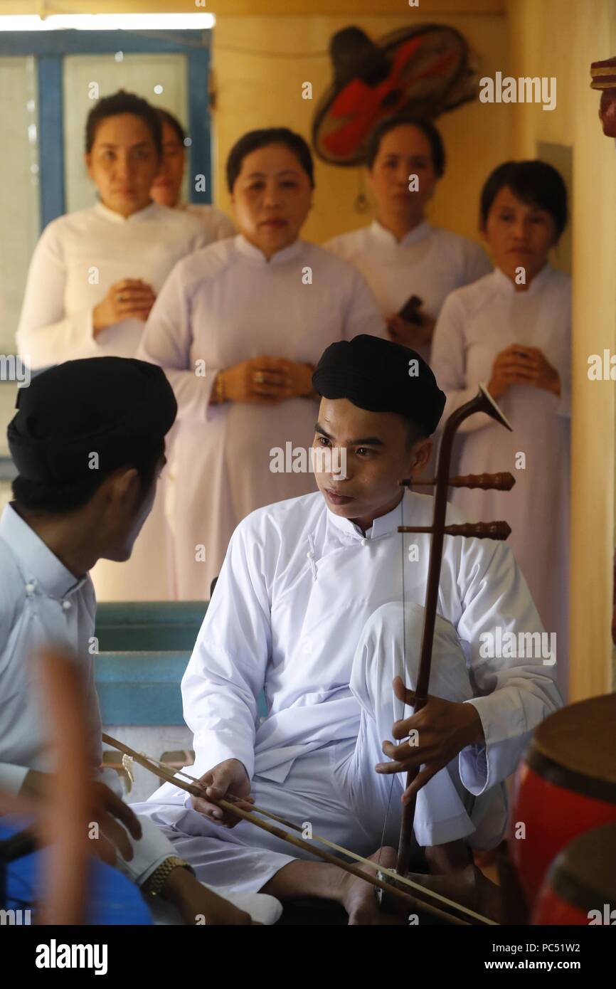 Cao Dai temple. Cao Dai worshipper play music at service. Phu Quoc ...