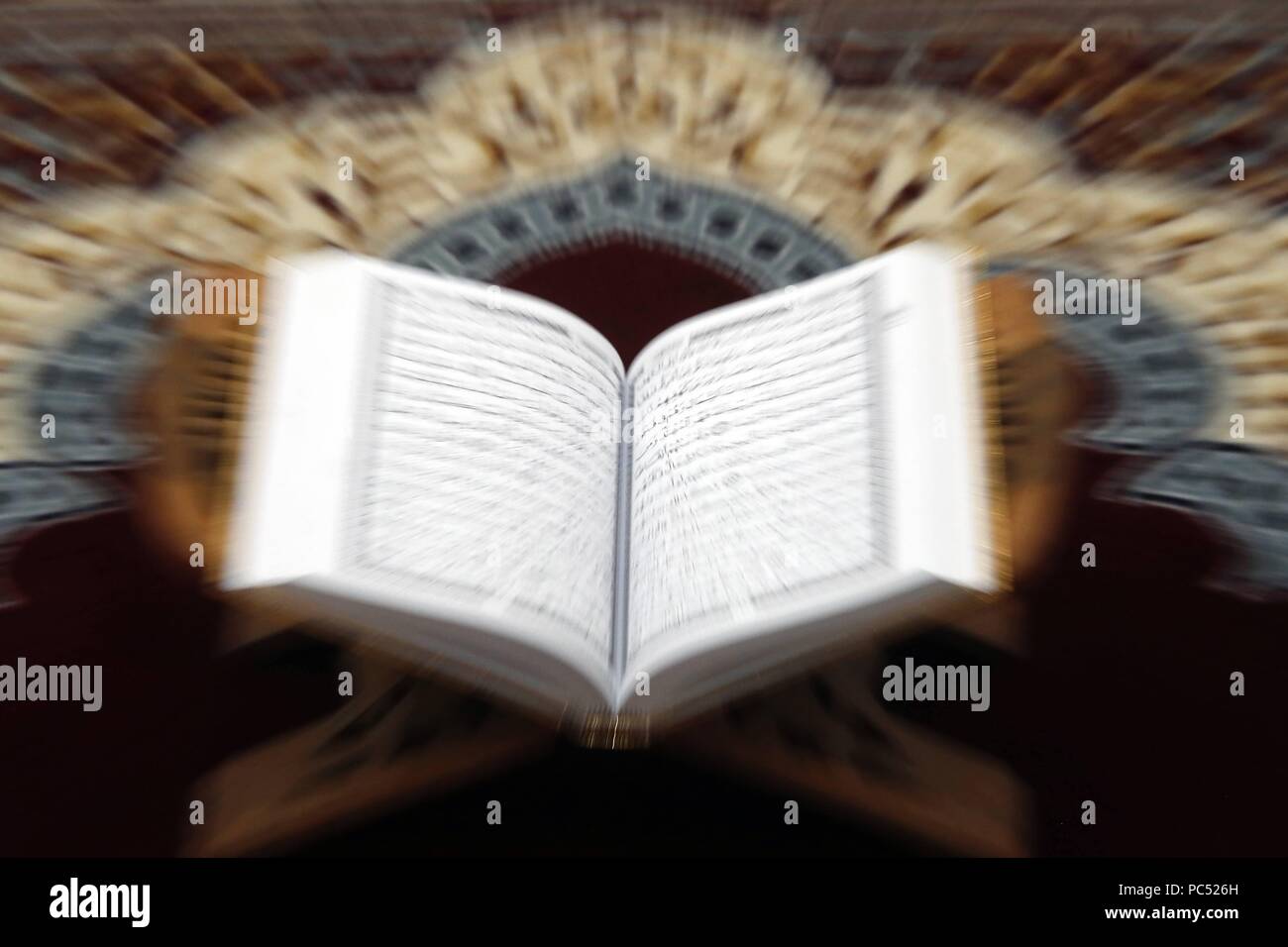 An open Holy Quran on wood stand. | usage worldwide Stock Photo - Alamy