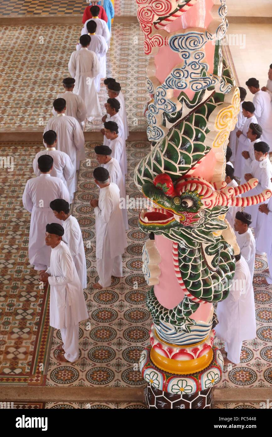 Cao Dai Holy See Temple. Caodaist service under dragon column. Thay ...