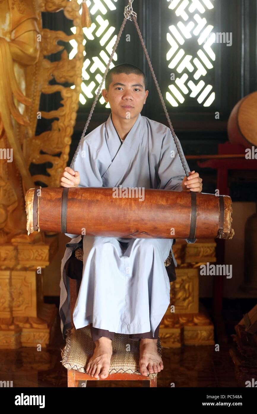 Linh An buddhist pagoda. Young monk ringing bell in monastery. Dalat ...