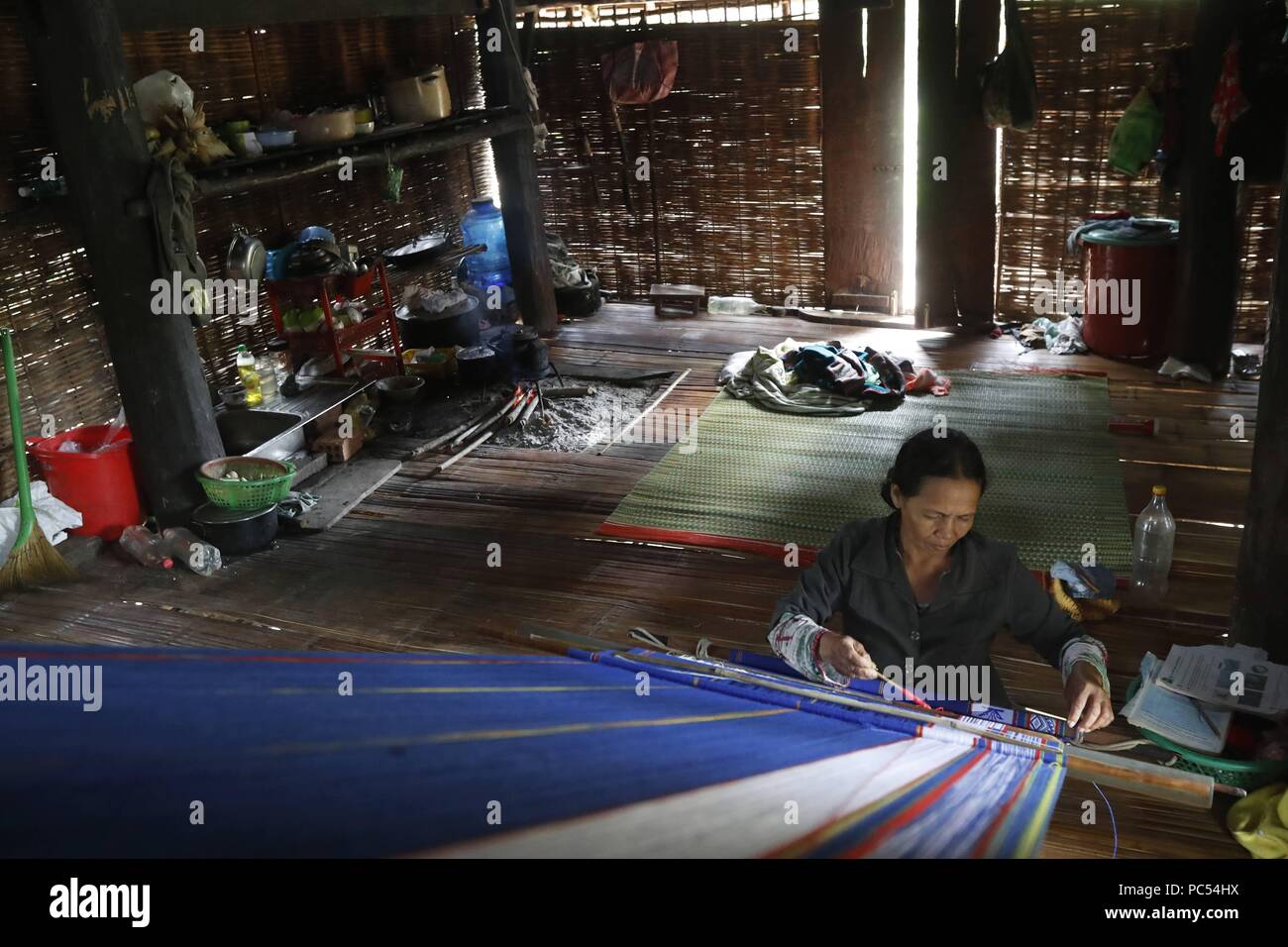 Bahnar (Ba Na) ethnic group. Woman weaving silk at wooden loom. Kon Tum ...