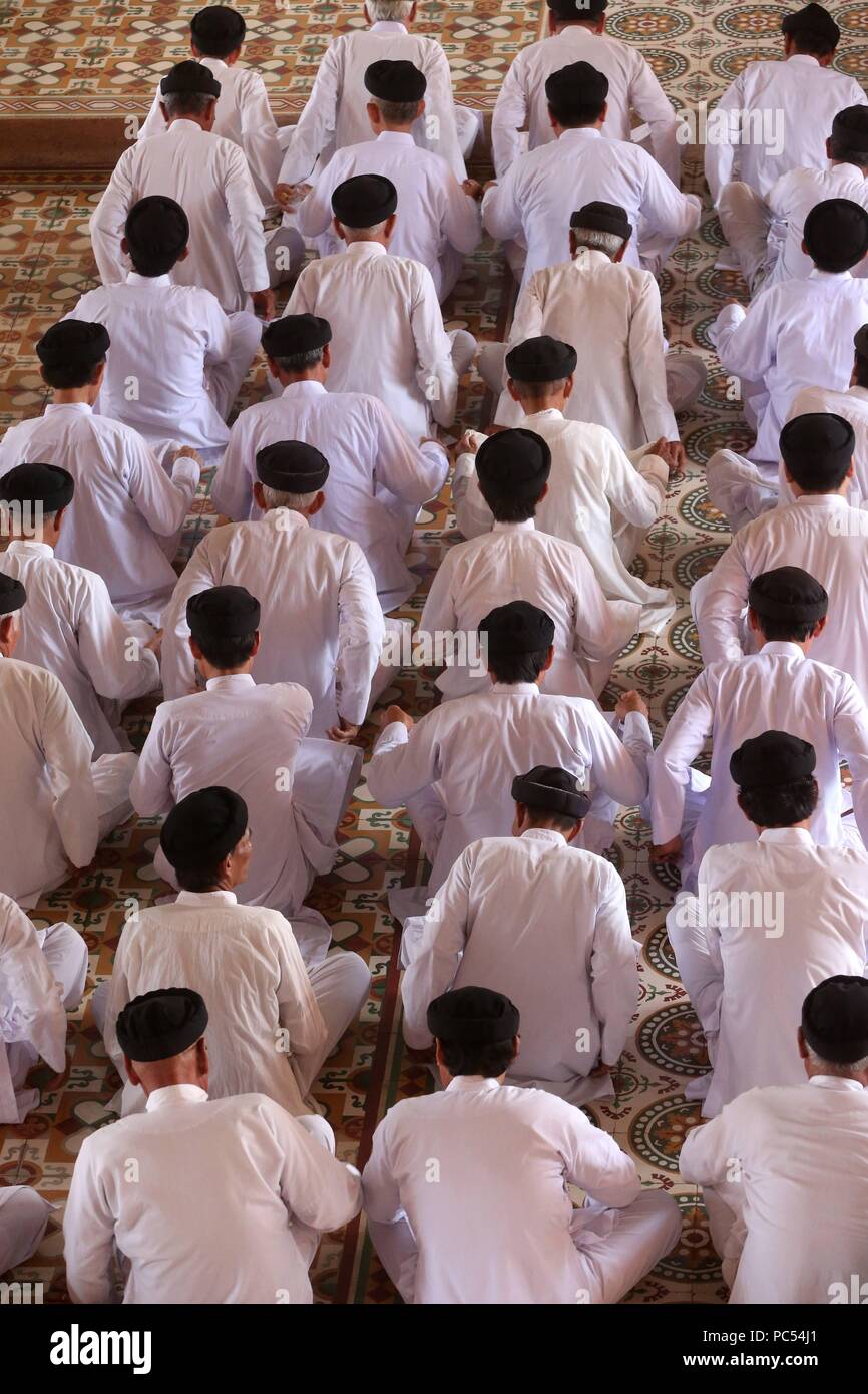 Cao Dai Holy See Temple. Praying devout men, ceremonial midday prayer ...