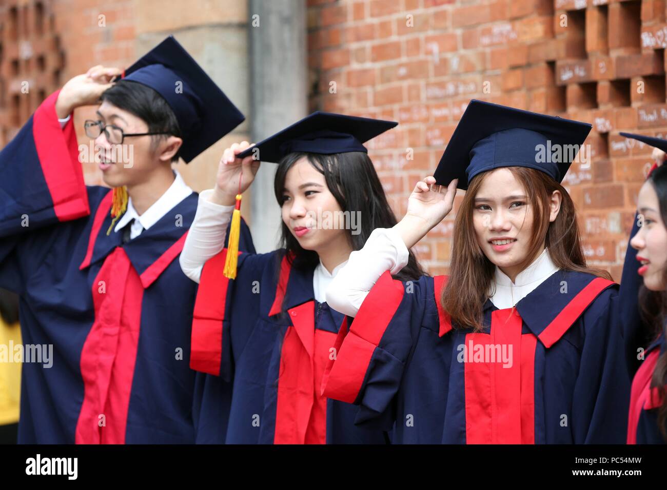 Group of Young Asian university students wearing cap and gown. Ho Chi ...