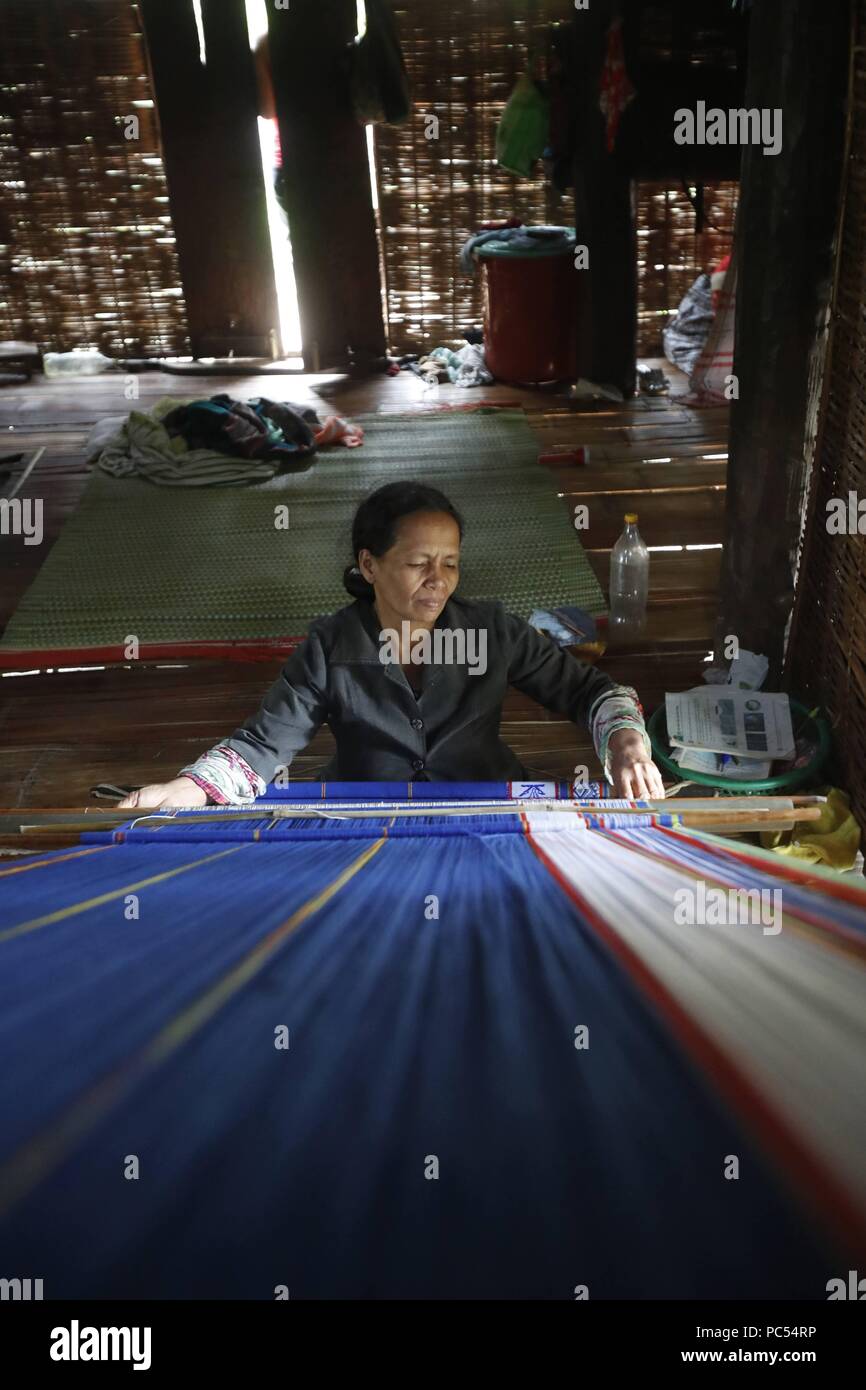 Bahnar (Ba Na) ethnic group. Woman weaving silk at wooden loom. Kon Tum ...