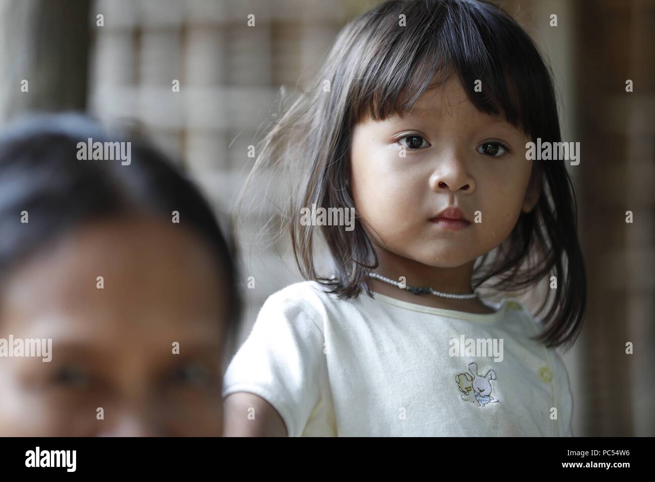 Bahnar (Ba Na) ethnic group. A woman and her daughter inside their ...
