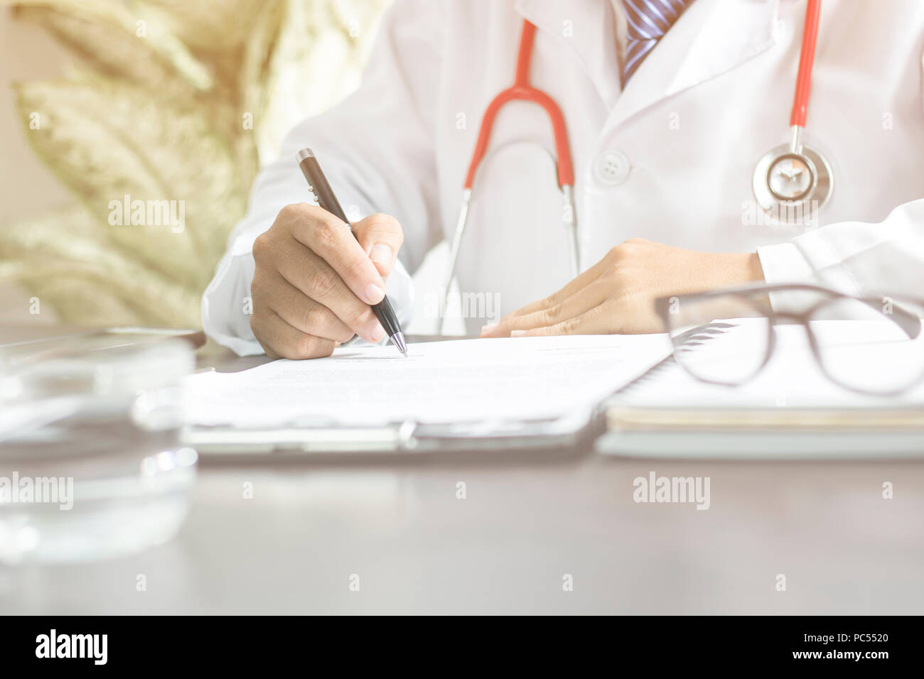 doctor writing information to patient on medicine paper in clinic for ...