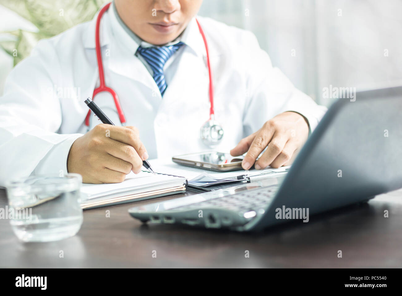 doctor writing information to patient on medicine paper in clinic for ...