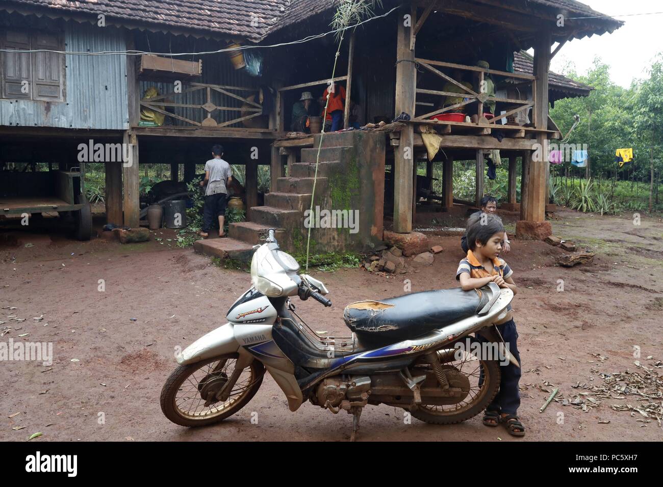 Jarai (Gia Rai) ethnic group. Motorbike and tradional house. Kon Tum ...