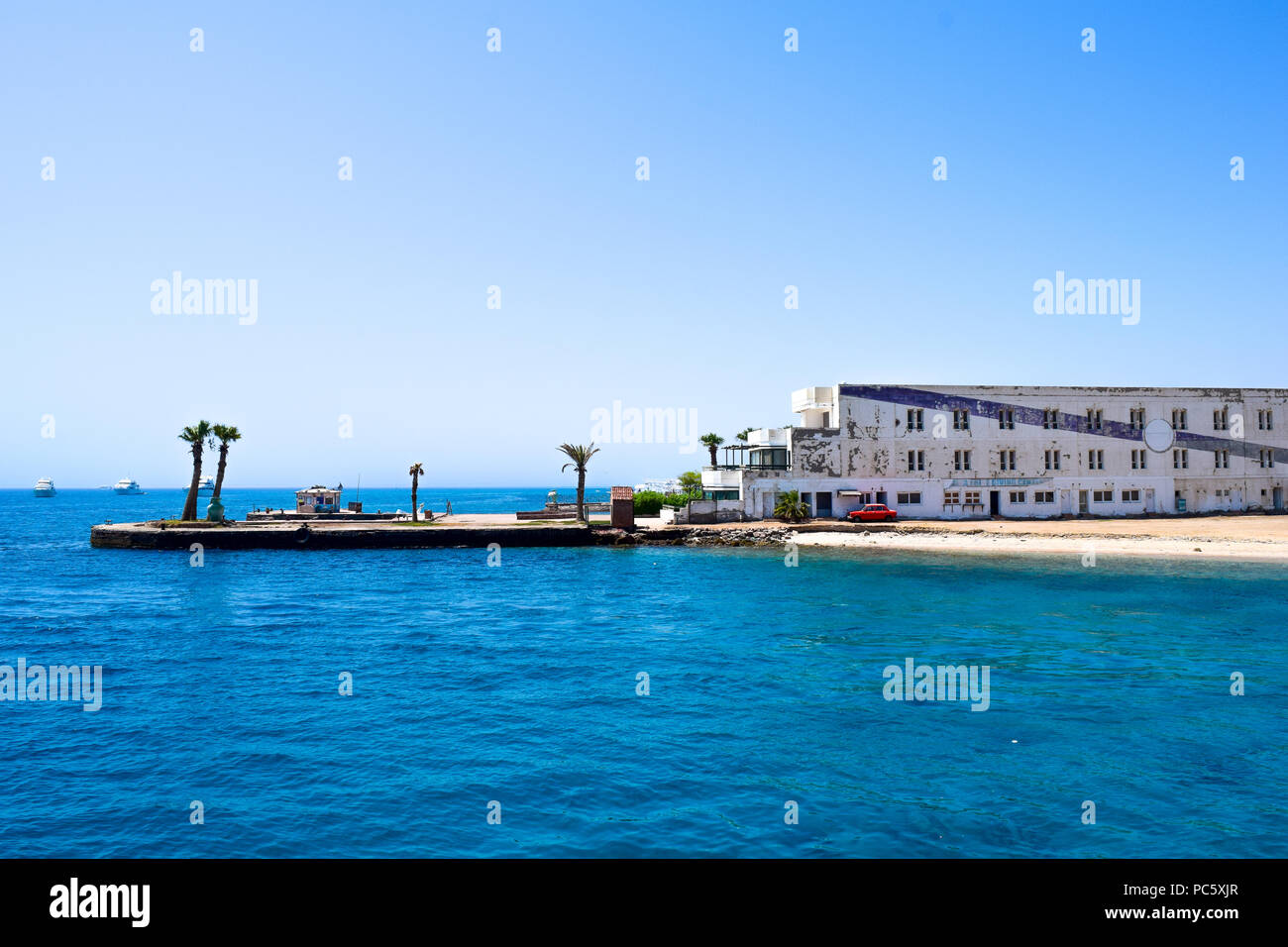 coast view, red car in front of an old building, port of Hurghada ...